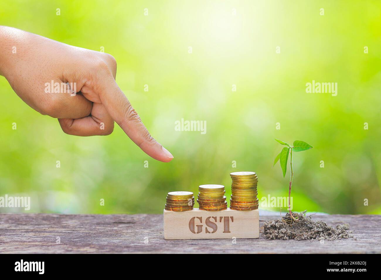 GST WORD WITH BUSINESSMAN HAND POINTING TO STACK OF GOLD COIN Stock ...