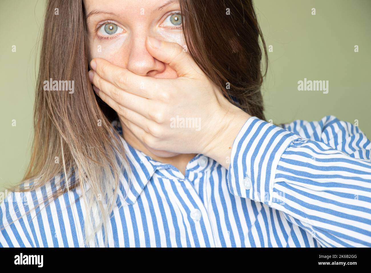A young girl covered her face with her hand, be quiet and don't say ...