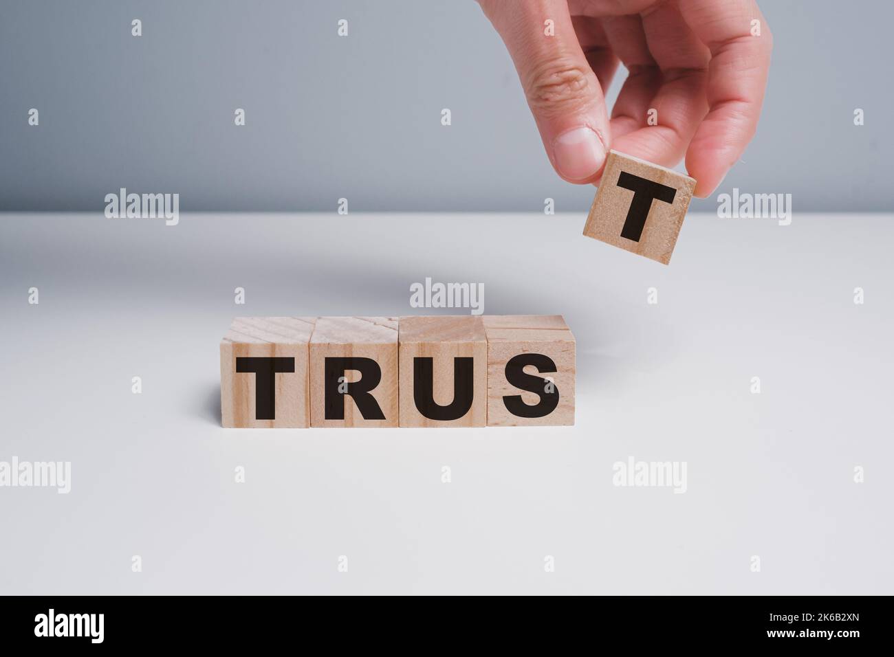 Hand of a man writing the word trust on wooden cubes, concept Stock ...
