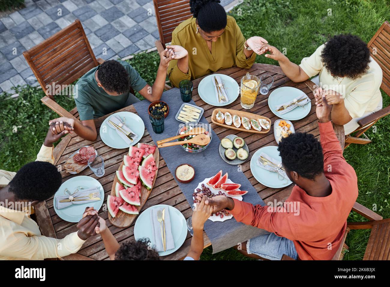Top view at group of African American people saying grace at picnic ...