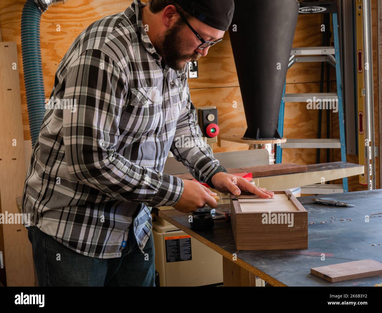a carpenter in his woodshop working on the box he is building Stock ...