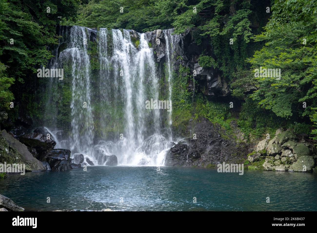 A beautiful shot of the splashing flowing Cheonjeyeon waterfall in Jeju ...