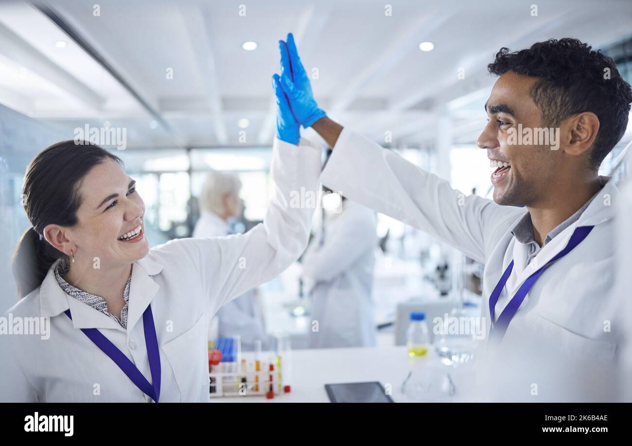 Two happy and cheerful scientists celebrating success with a high five ...