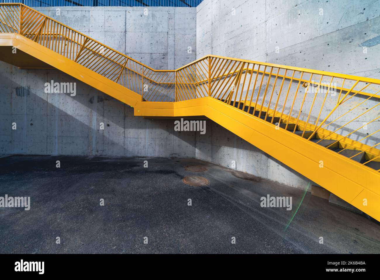 The yellow steel metal stairs going up a gray stone wall Stock Photo ...