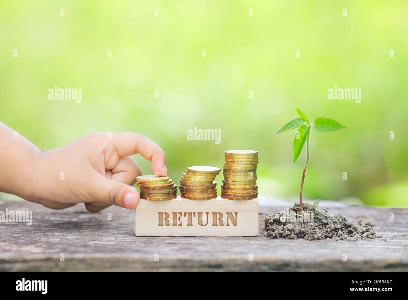 RETURN WORD Golden coin stacked with wooden bar Stock Photo - Alamy