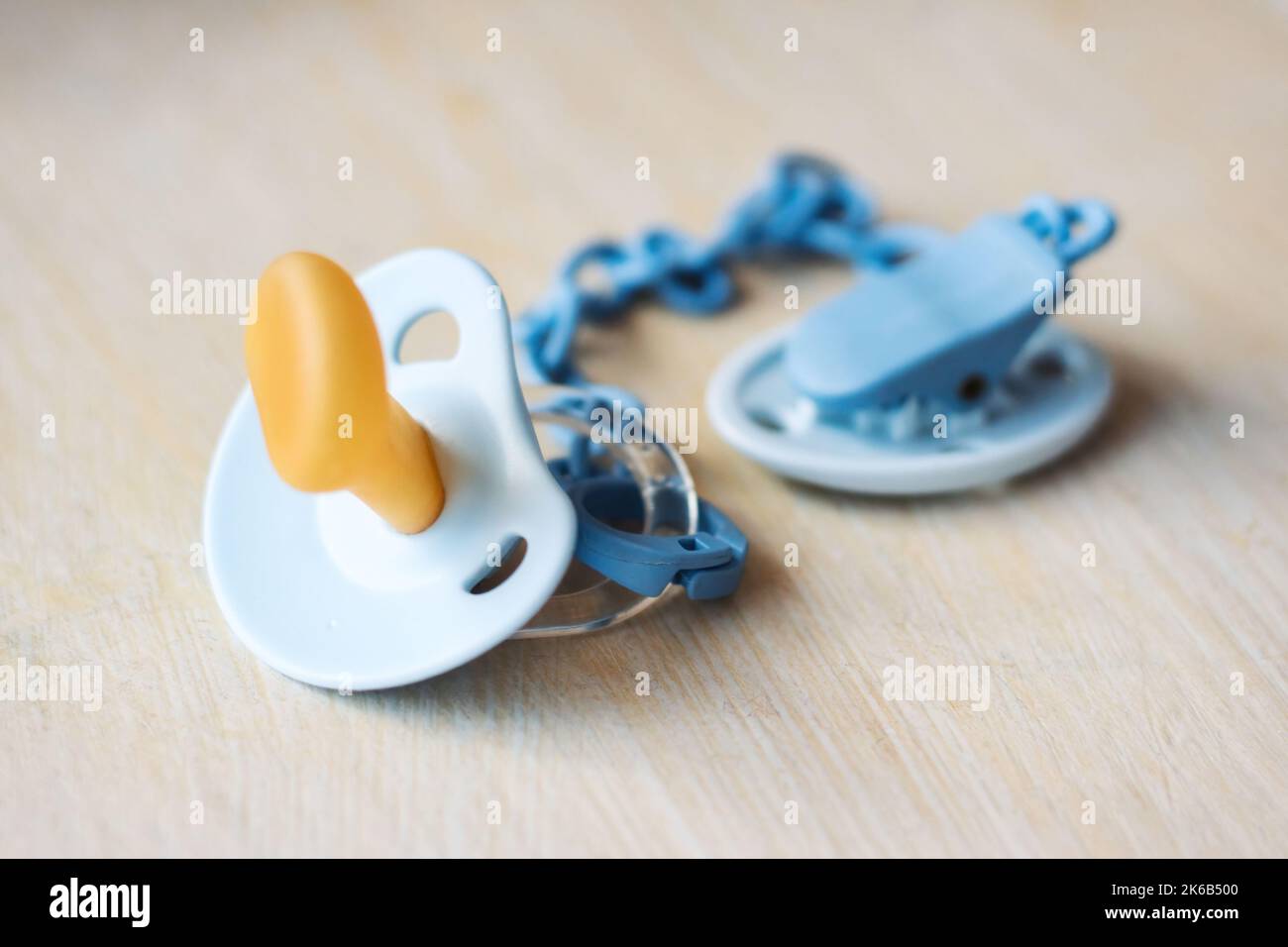 A baby's latex dummy or pacifier with a plastic chain isolated on a ...