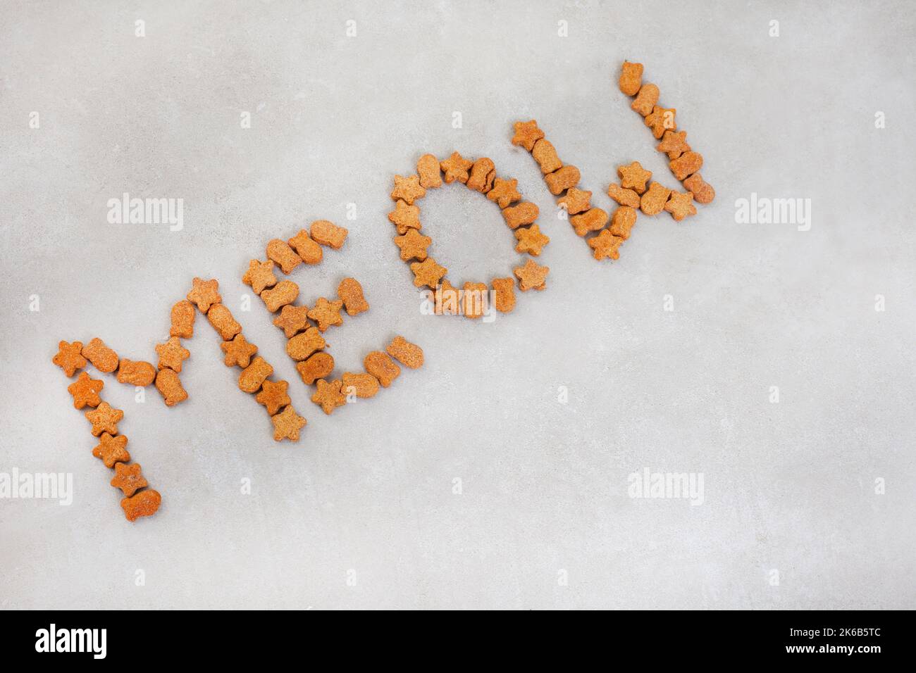 Meow written in cat treats on mottled grey surface Stock Photo - Alamy