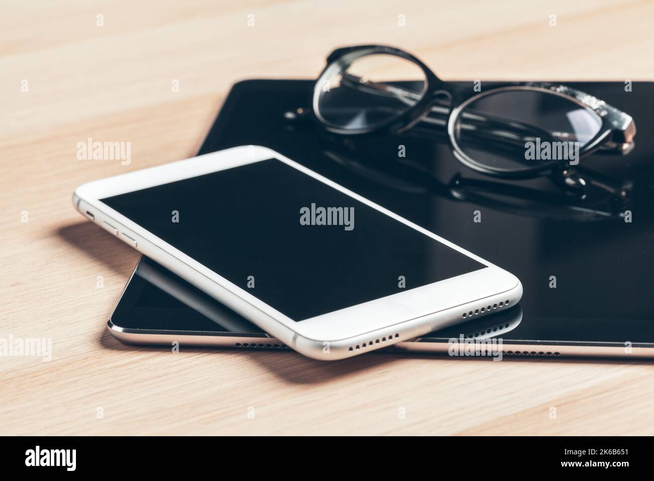 Digital tablet and mobile phone. Electronic devices on wooden table ...