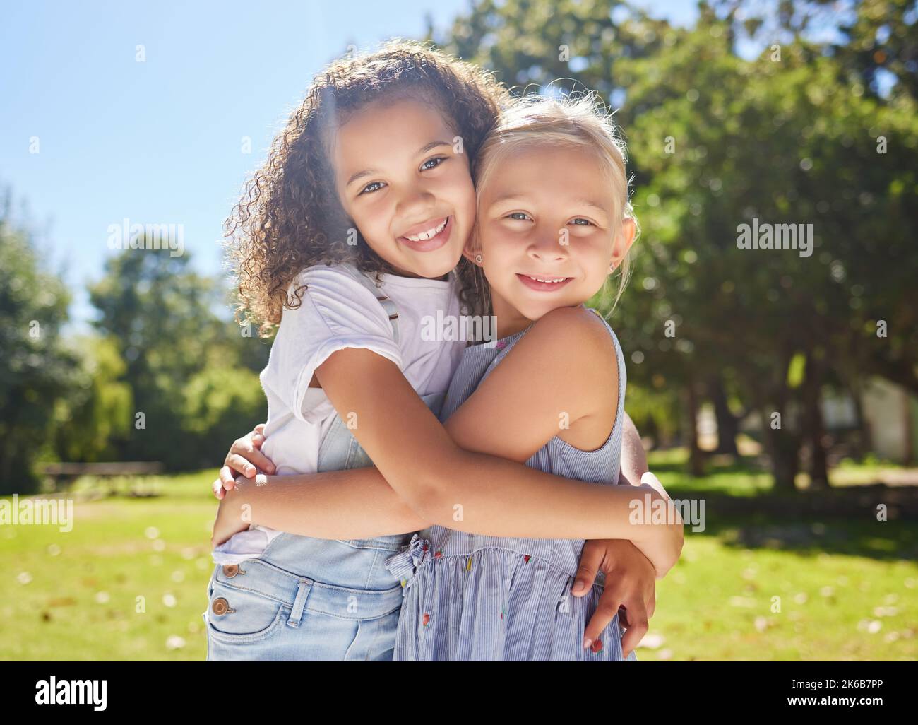 Our very own little hideout. two friends hugging in a park Stock Photo ...