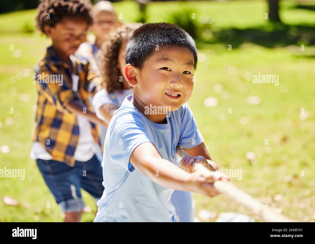 The winning team works as one. a group of kids playing a game of tug of ...