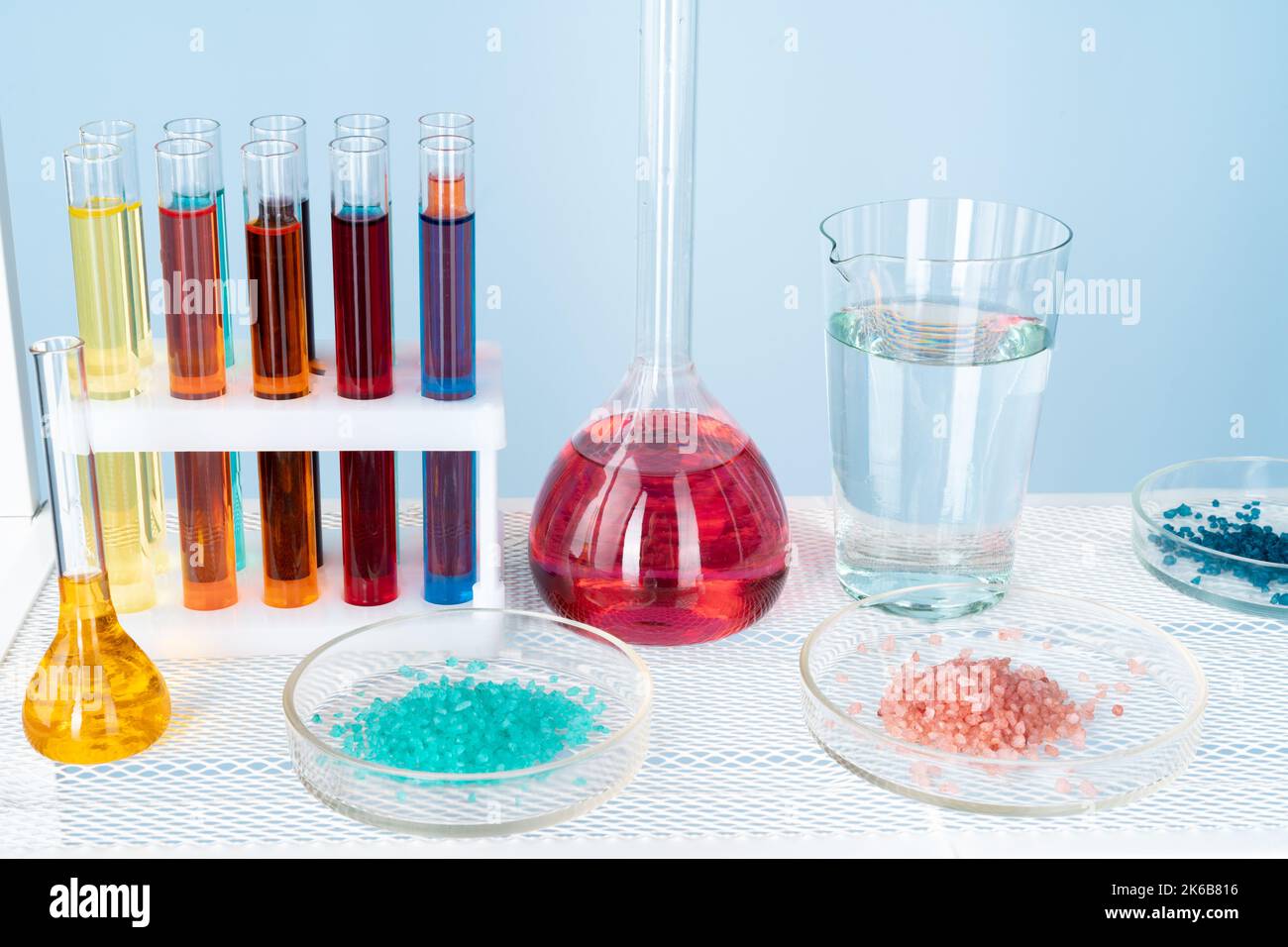 Chemical laboratory glassware with various colored liquids on table ...