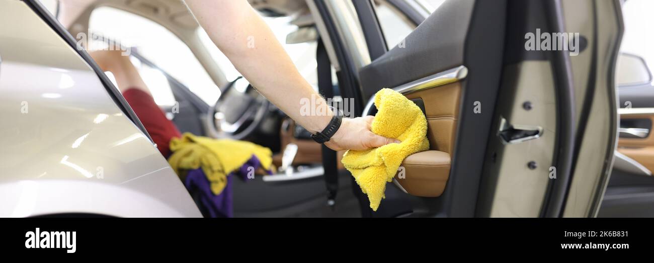 Car wash service worker wipes car door with rag wipes Stock Photo - Alamy