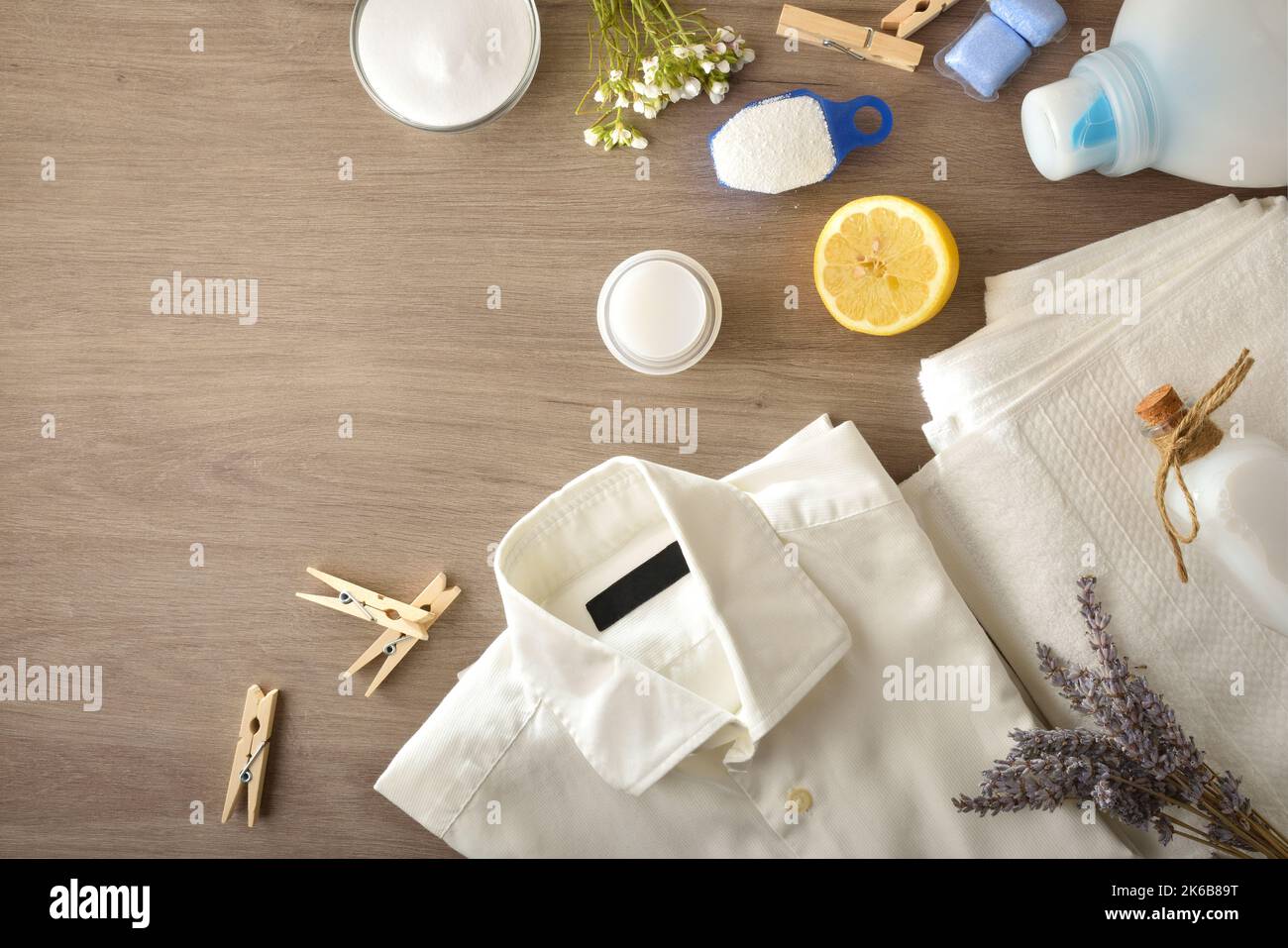 Clothes washing background with towels and products on wooden table ...