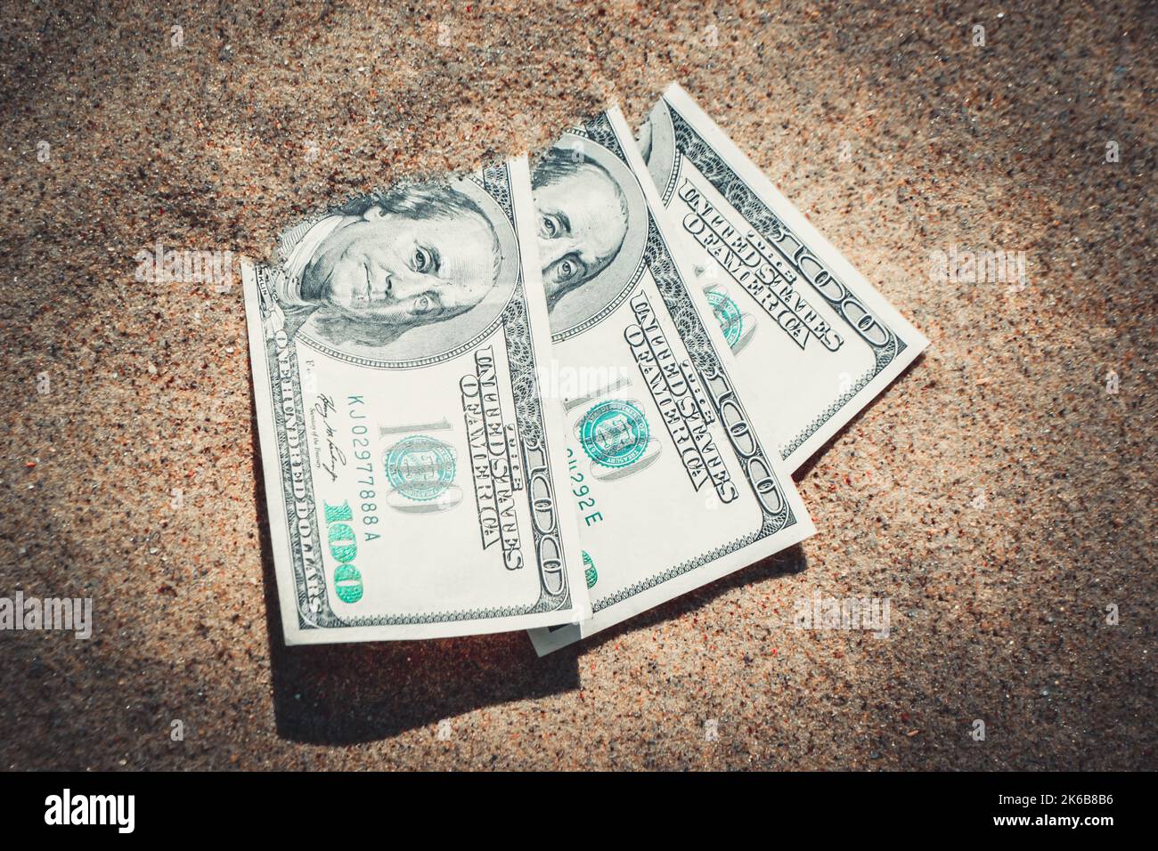 Money dolars half covered with sand lie on beach close-up. Dollar bills ...