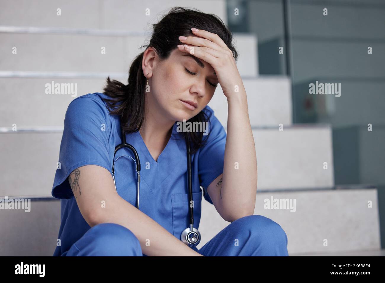 The long hours are taking a toll. a young female doctor looking tired ...