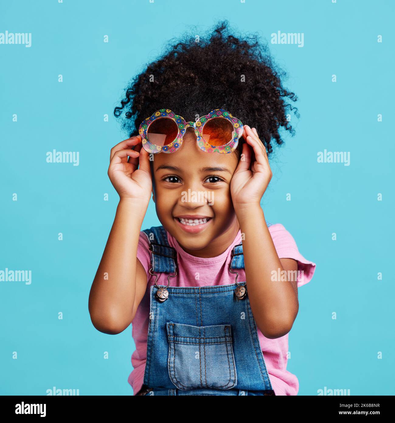 Im even cooler with glasses. an adorable little girl posing against a ...