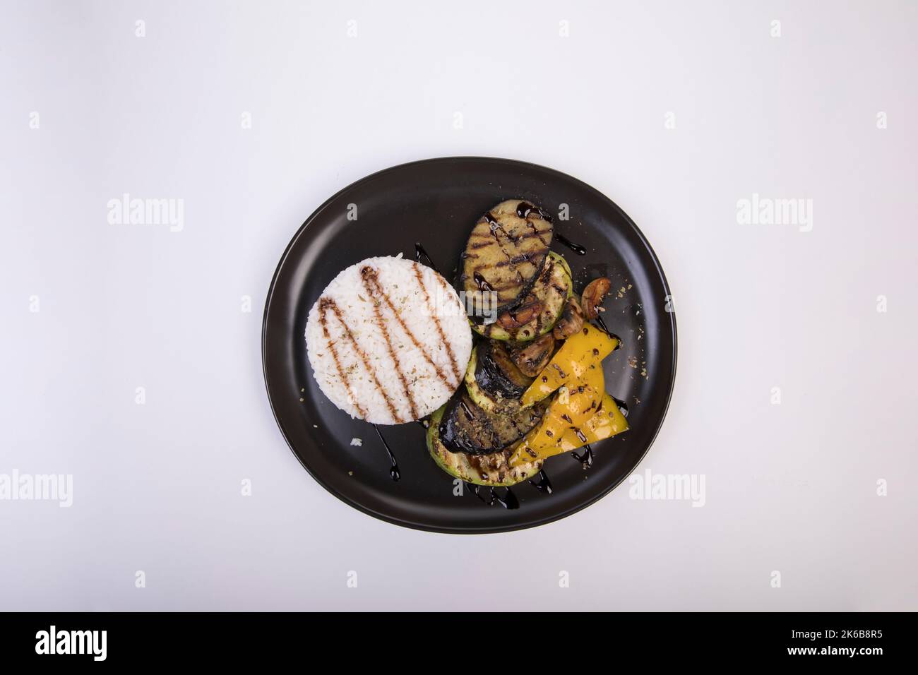 A top view of grilled vegetables with rice on a black plate Stock Photo ...