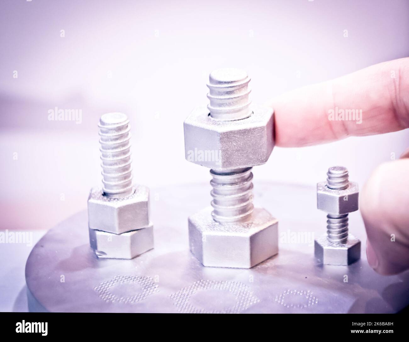 Man is turns detail of object printed on metal 3d printer. Object ...