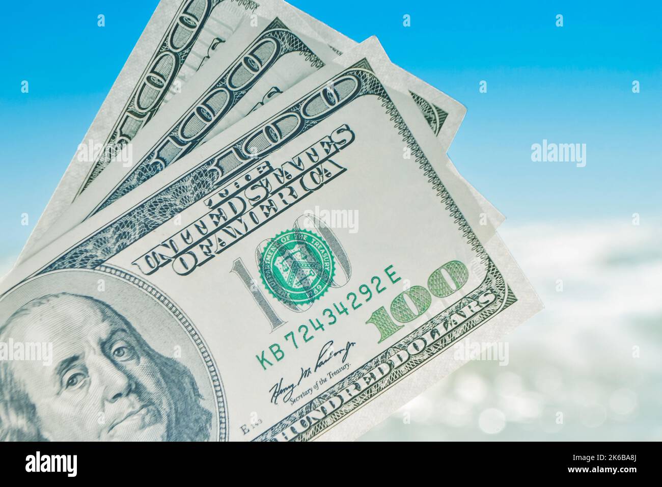 Girl holding money bill of 300 dollars on background of sea ocean waves ...