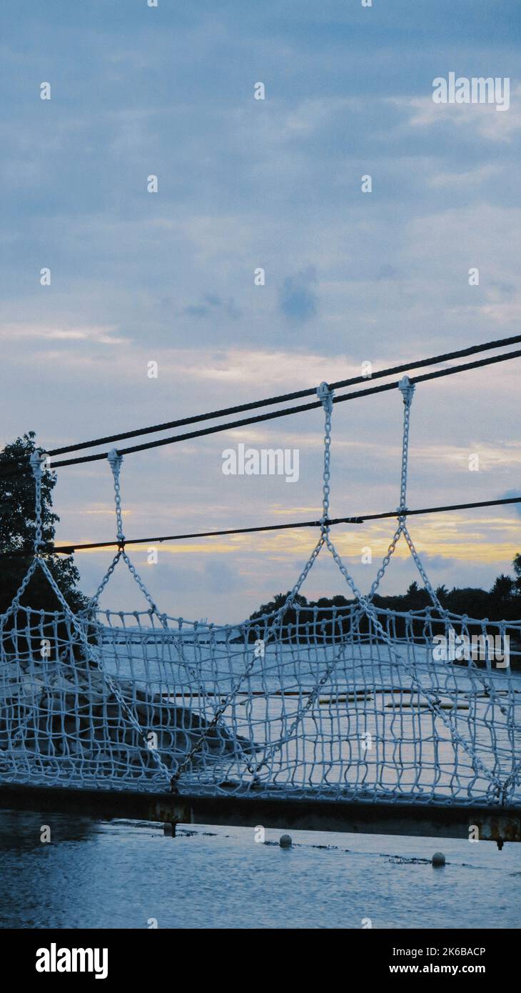 A vertical of a metal mesh bridge with chains connecting the net ...