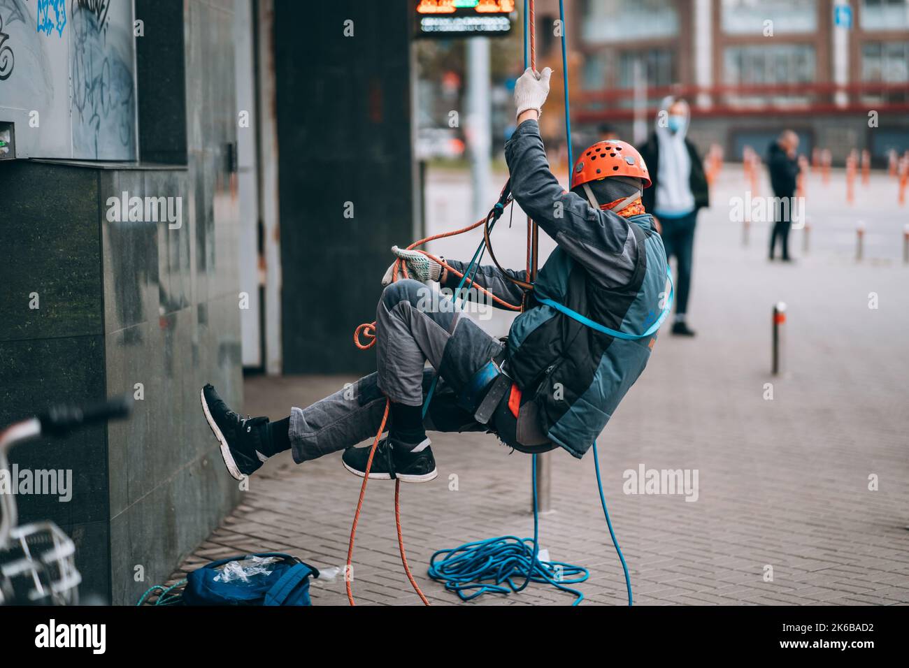 Industrial climber in uniform and helmet rises Stock Photo - Alamy