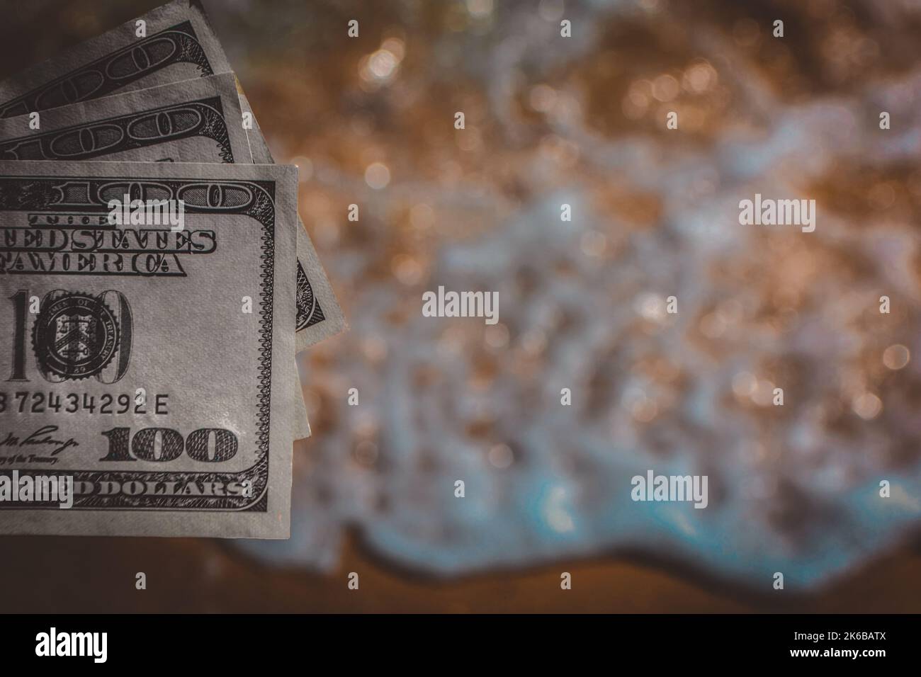 Girl holding money bill of 300 dollars on background of sea ocean waves ...