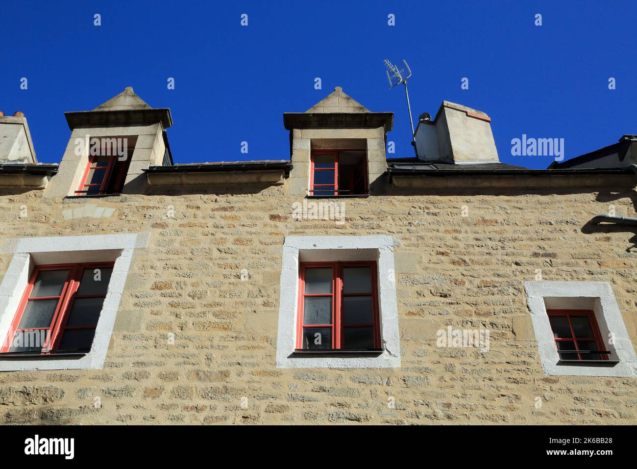 Stone building with red painted window frames and white surrounds in ...