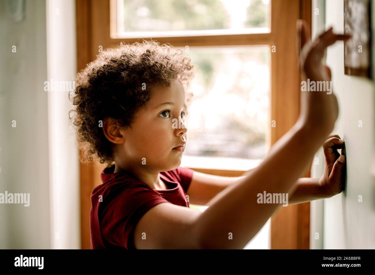 Curious boy using home automation on wall Stock Photo - Alamy