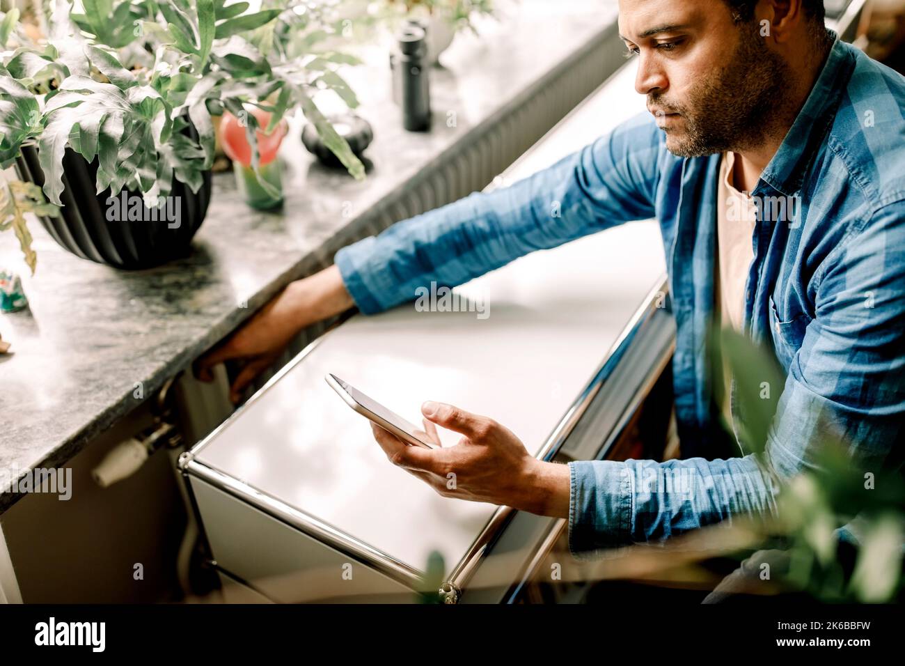 Man checking temperature of radiator through mobile phone at home Stock ...
