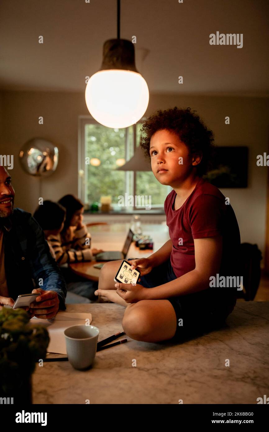Boy controlling light through home automation system on smart phone ...
