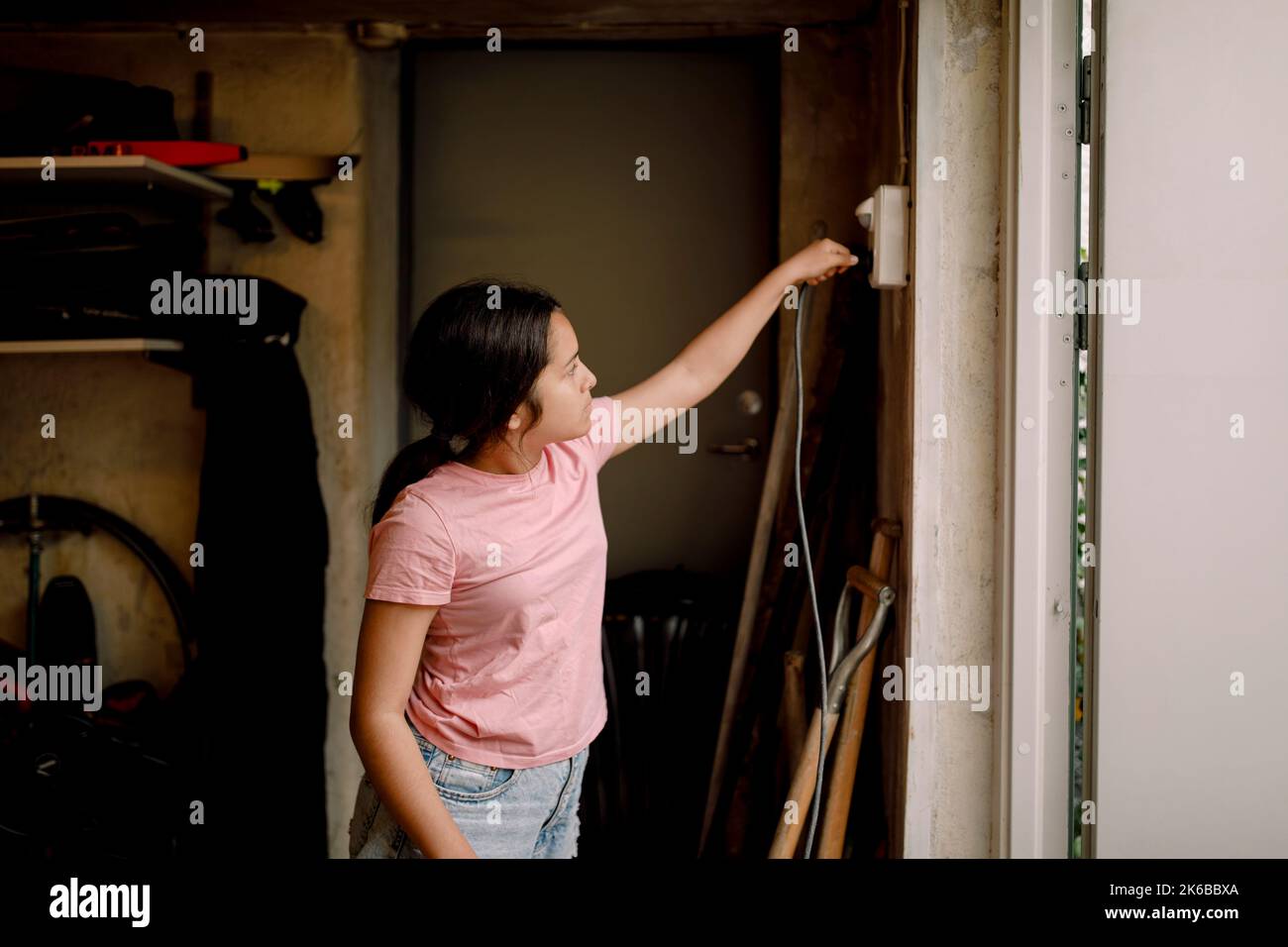 Girl plugging cable in electric socket at storage room Stock Photo - Alamy