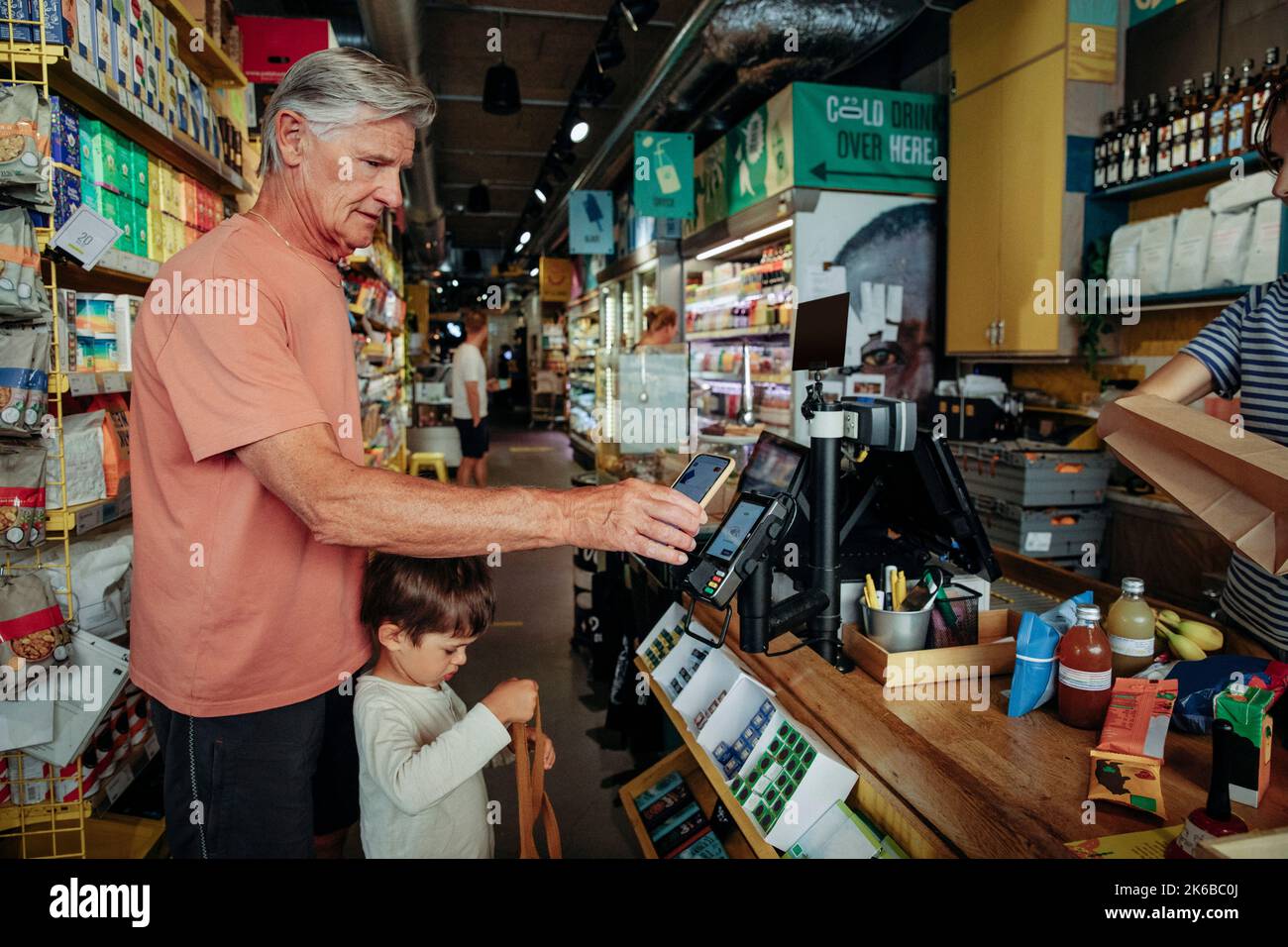 Side view of senior man doing online payment while standing with ...