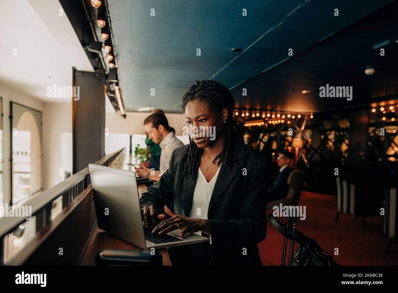 Young businesswoman using laptop while working in hotel lounge Stock ...