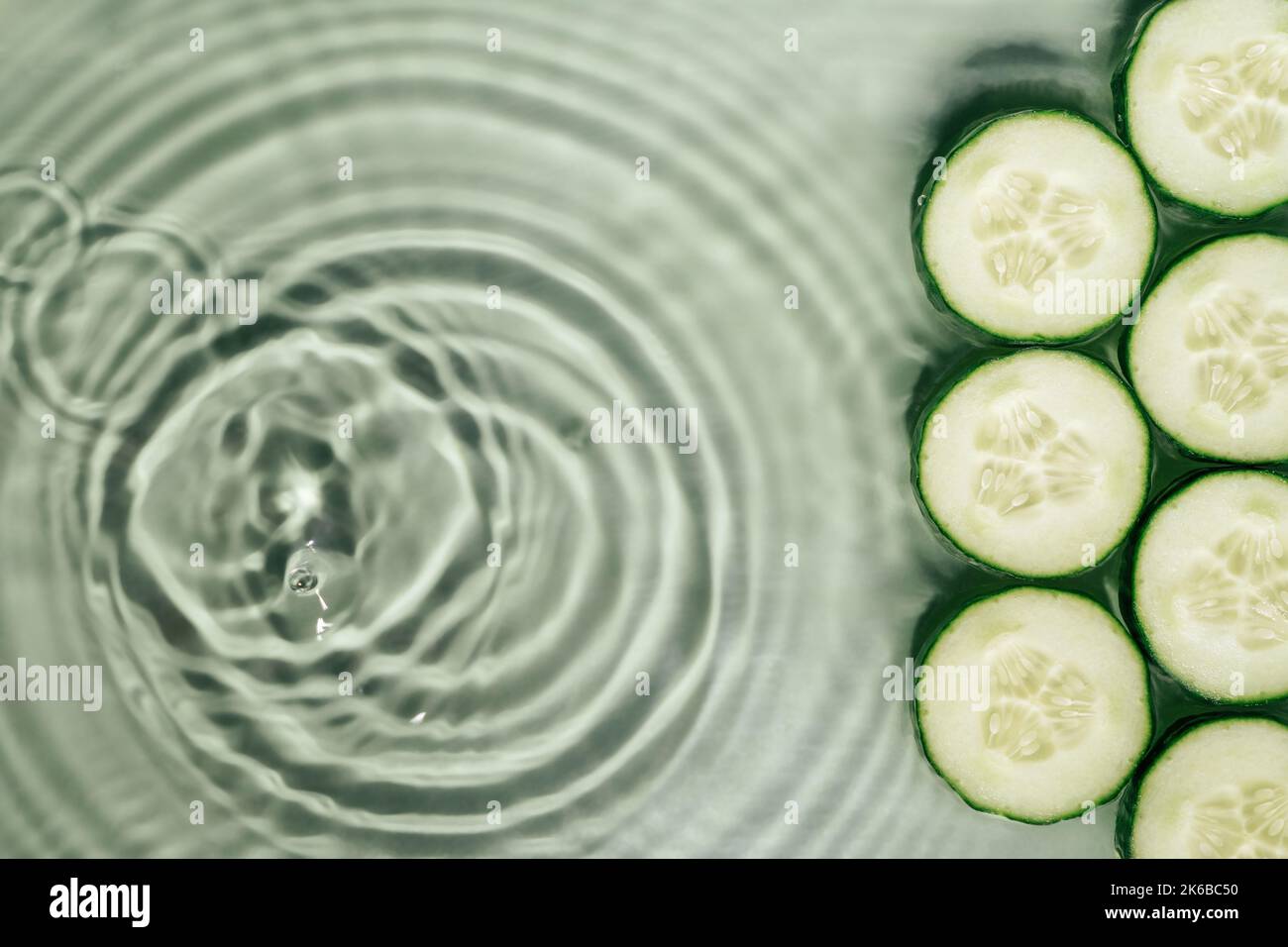 Cucumber slices lie on surface of rippled transparent fresh green ...
