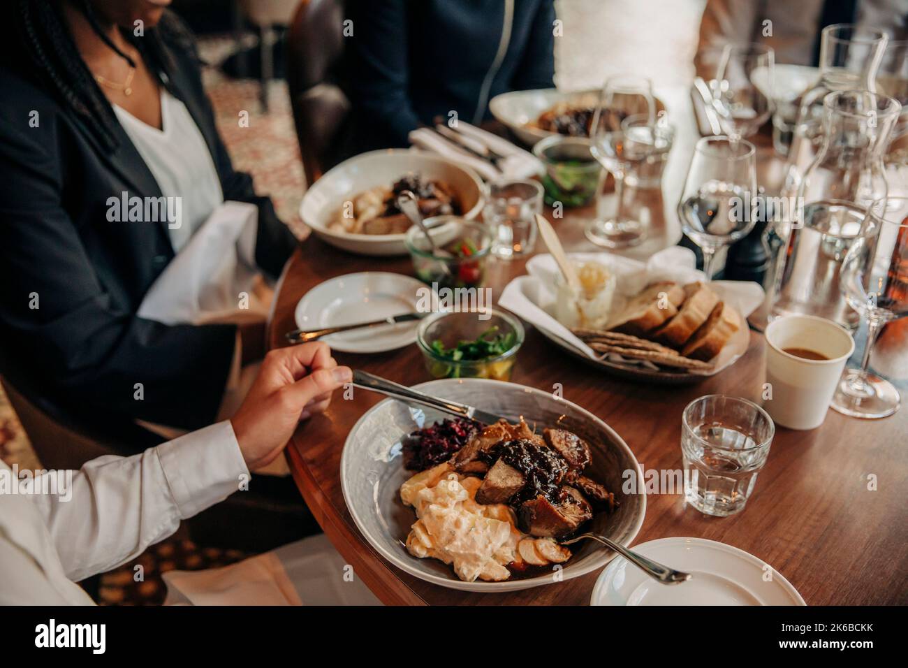 Young businessman having food with colleagues in hotel Stock Photo - Alamy