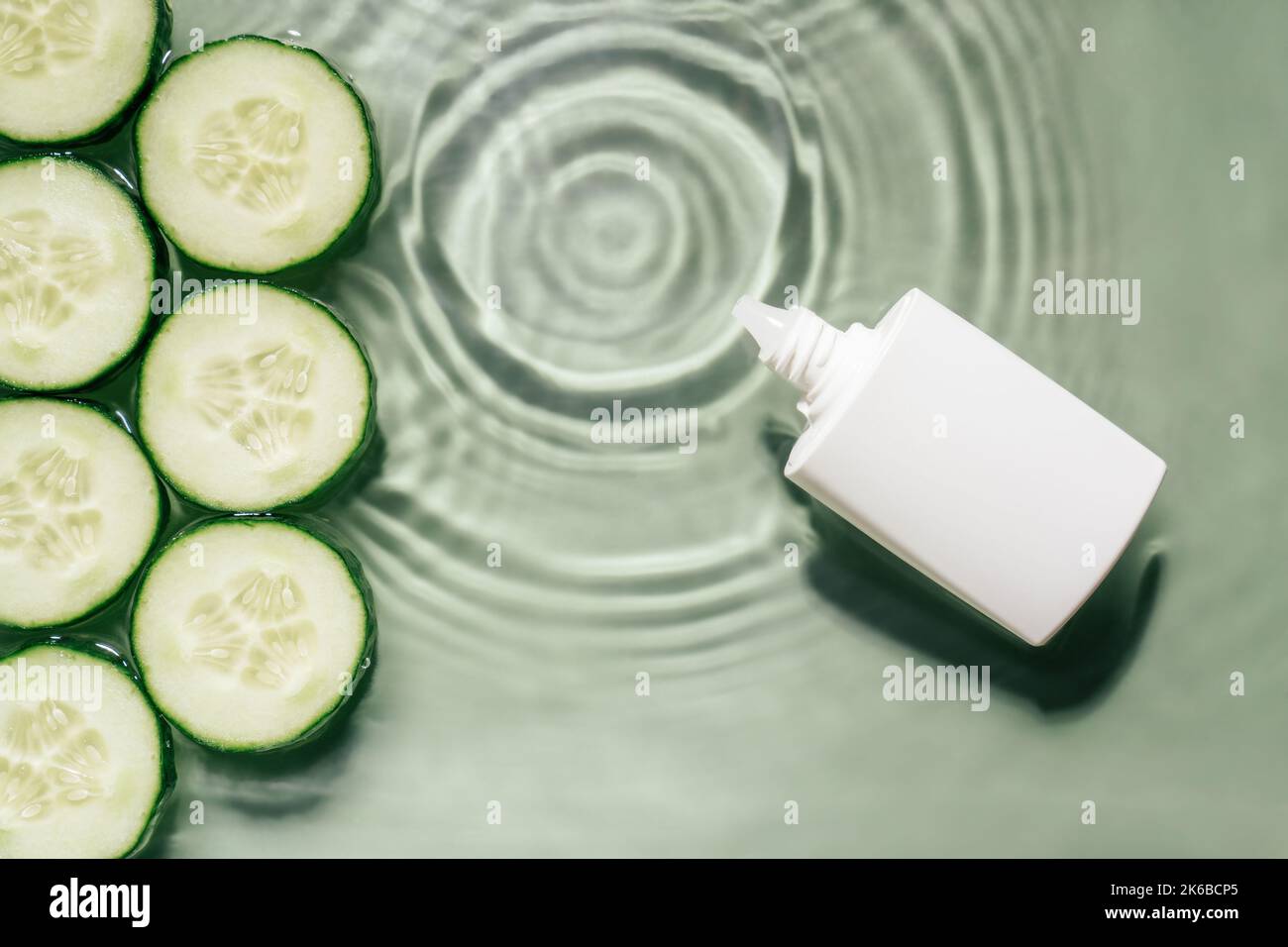 White beauty product cream vial tube bottle with rows of cucumber ...