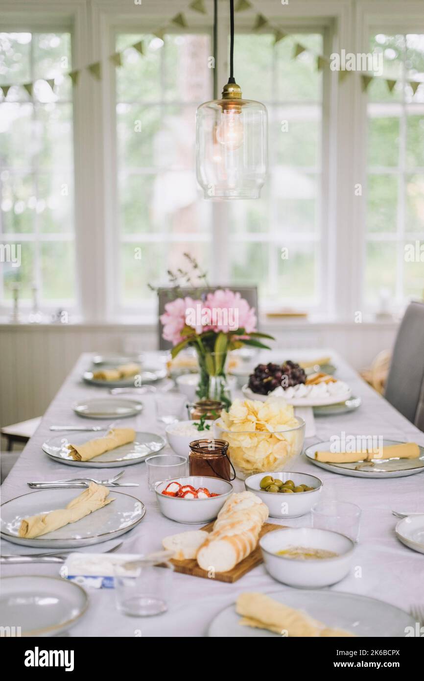 Food in plates arranged on dining table at home Stock Photo - Alamy