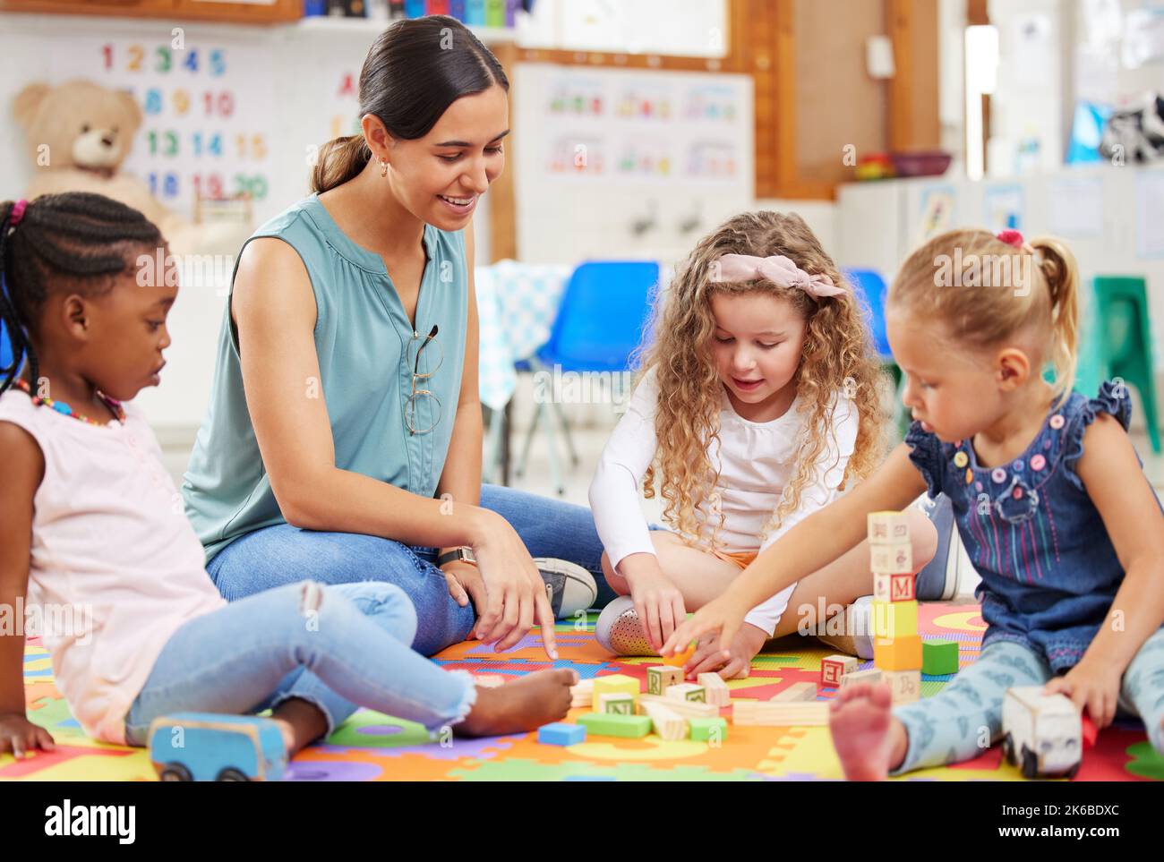 Teacher and kids looking happy while doing activity at kindergarten or ...