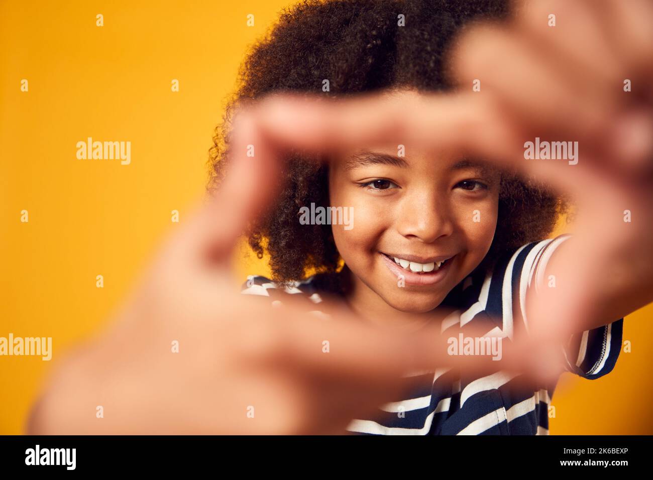 Studio Portrait Of Smiling Boy Making Shape Of Picture Frame With Hands ...