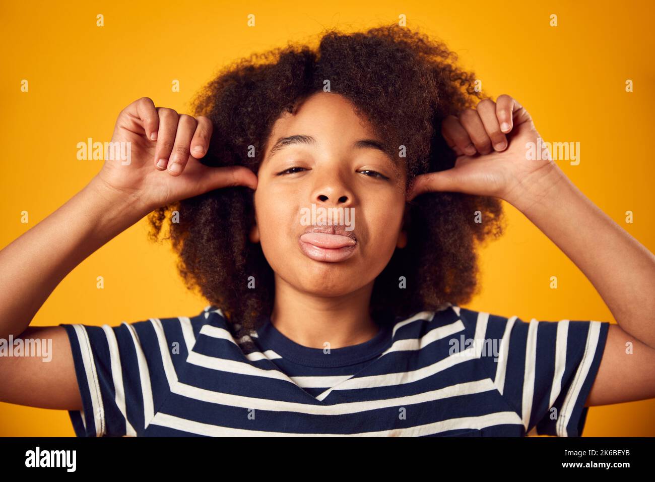 Studio Portrait Of Smiling Young Boy Pulling Funny Face Shot Against ...