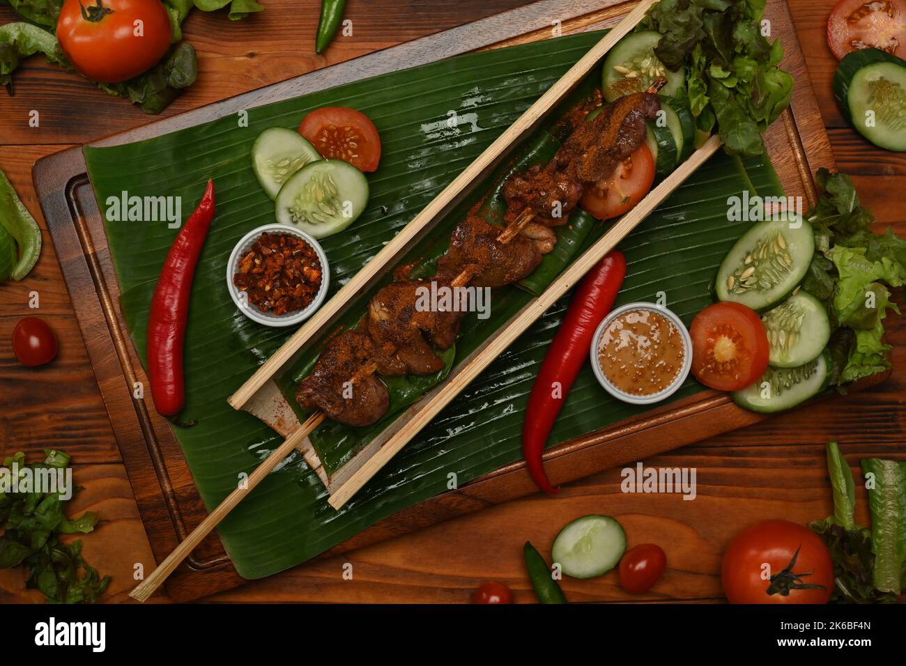 Top view of grilled meat served in bamboo barrel plat with Sichuan pepper, Chinese spices and ...