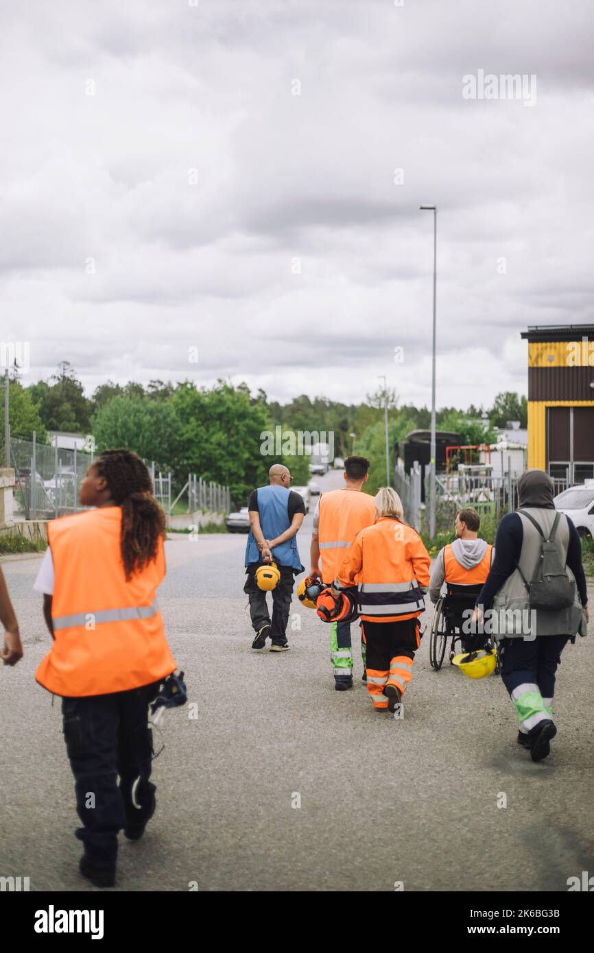 Male and female construction workers walking together on road Stock ...