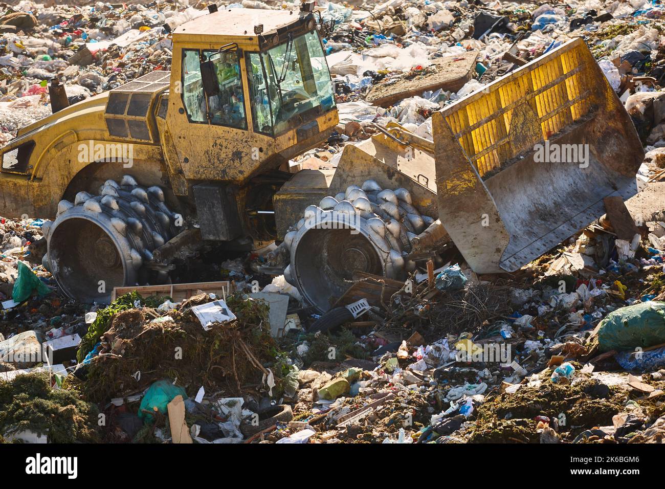 Heavy machinery shredding garbage in an open air landfill. Waste Stock ...