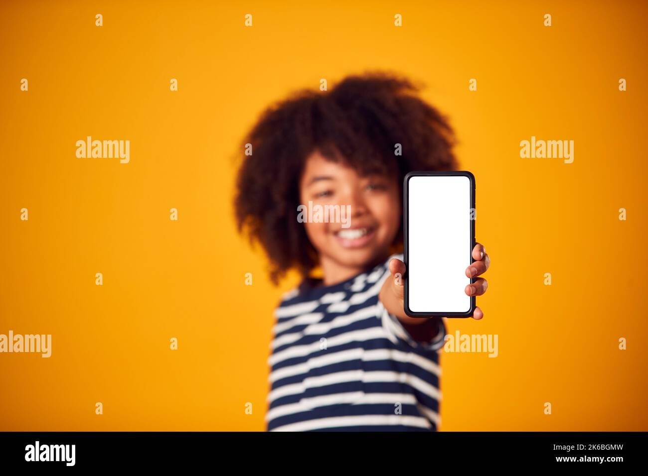 Studio Portrait Of Boy Showing Mobile Phone With Social Media Screen ...