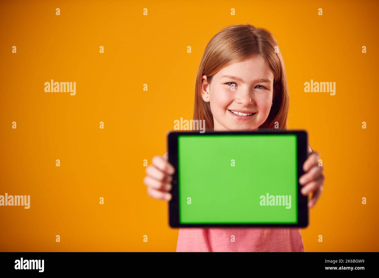 Studio Portrait Of Girl Using Digital Tablet With Green Screen Against ...