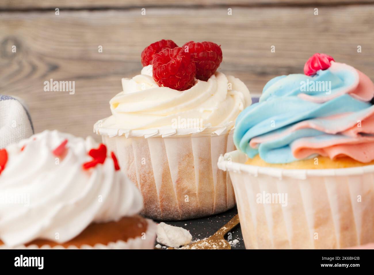 Tasty cupcakes on a dark wooden table Stock Photo - Alamy