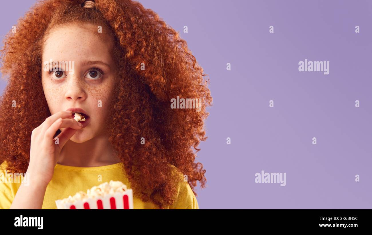 Scared Girl Watching Horror Movie And Eating Popcorn At Cinema Against ...