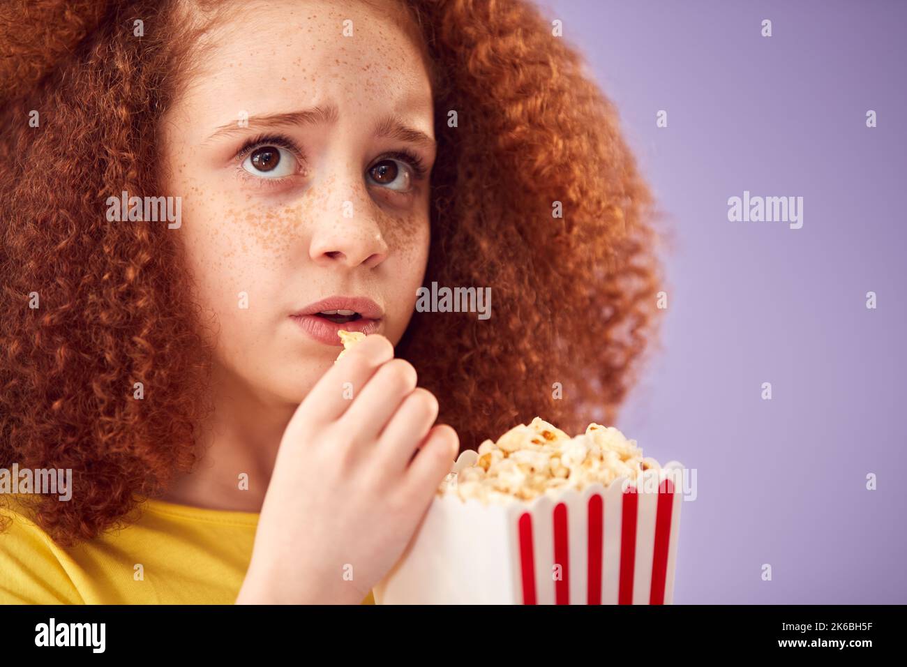 Scared Girl Watching Horror Movie And Eating Popcorn At Cinema Against ...