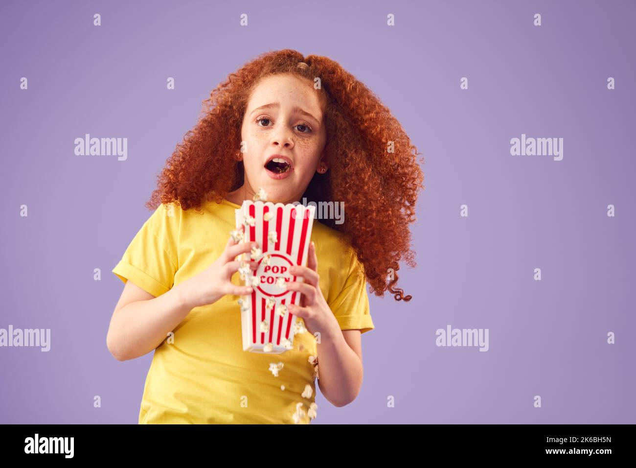 Scared Girl Watching Horror Movie And Eating Popcorn At Cinema Against ...