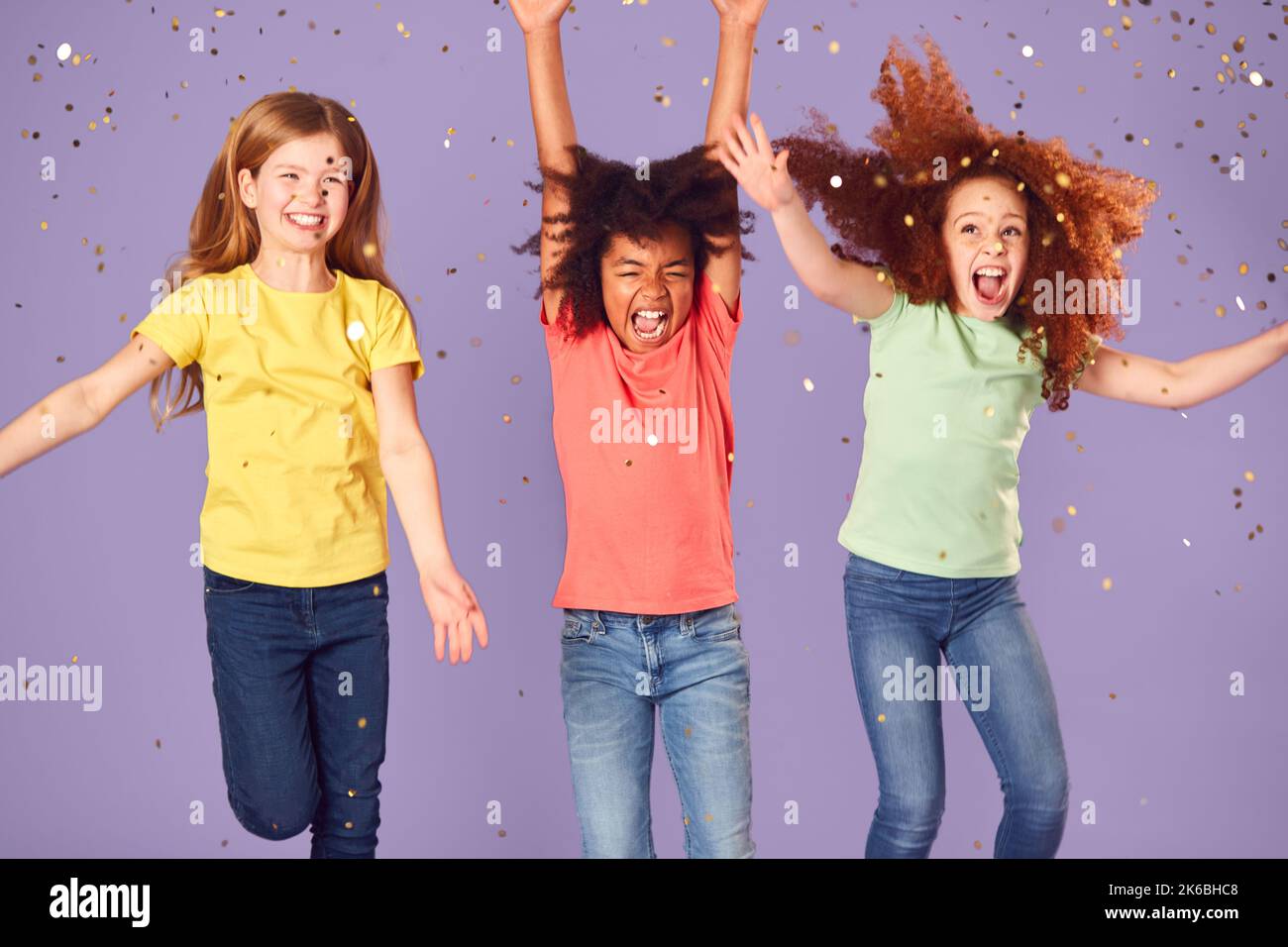 Studio Shot Of Children With Glitter Jumping In The Air With ...